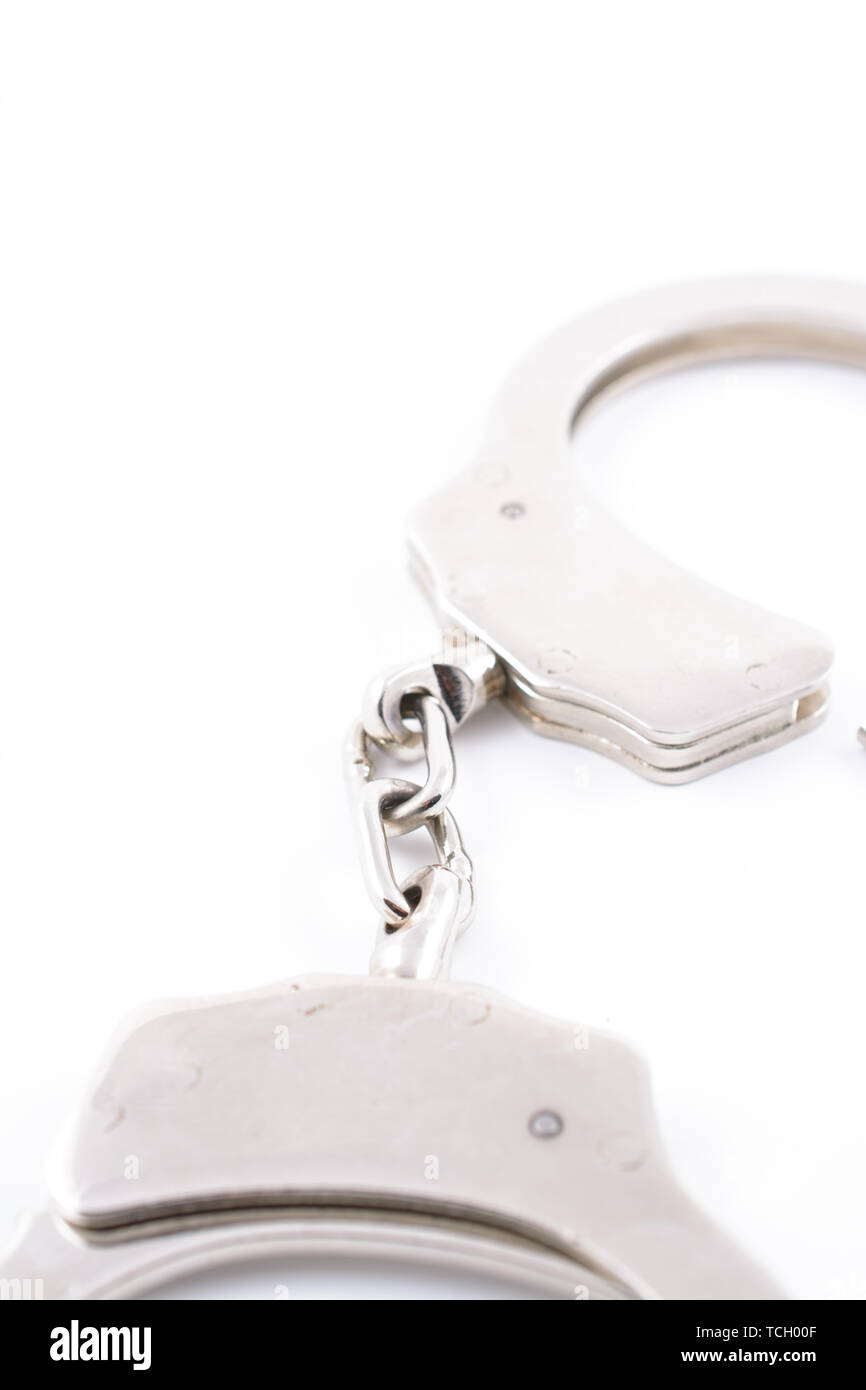Shiny metal chrome handcuffs on a white background Stock Photo - Alamy