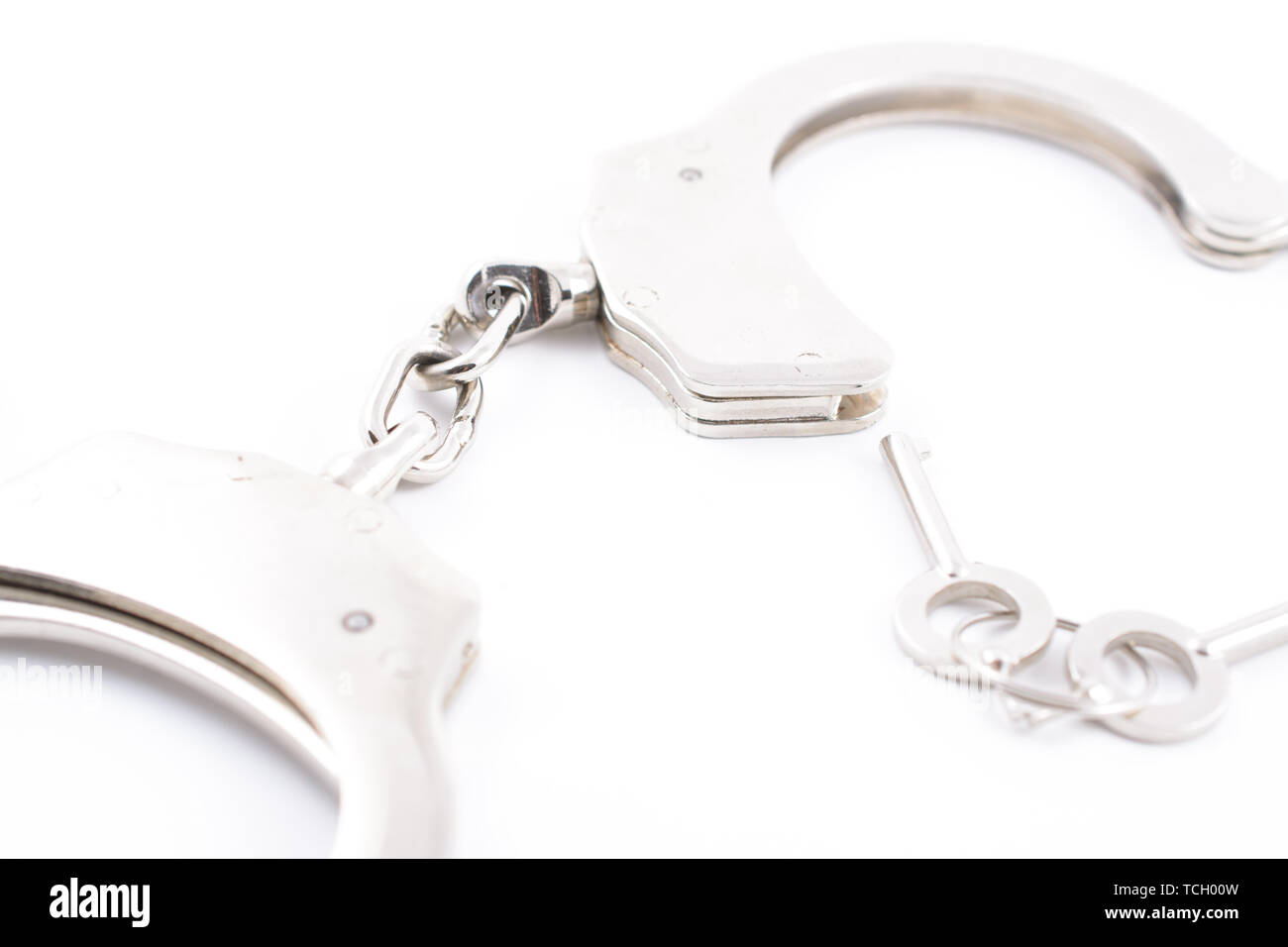 Shiny metal chrome handcuffs on a white background Stock Photo - Alamy