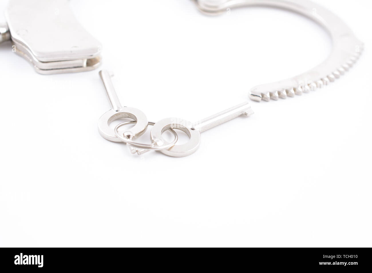 Shiny metal chrome handcuffs on a white background Stock Photo - Alamy
