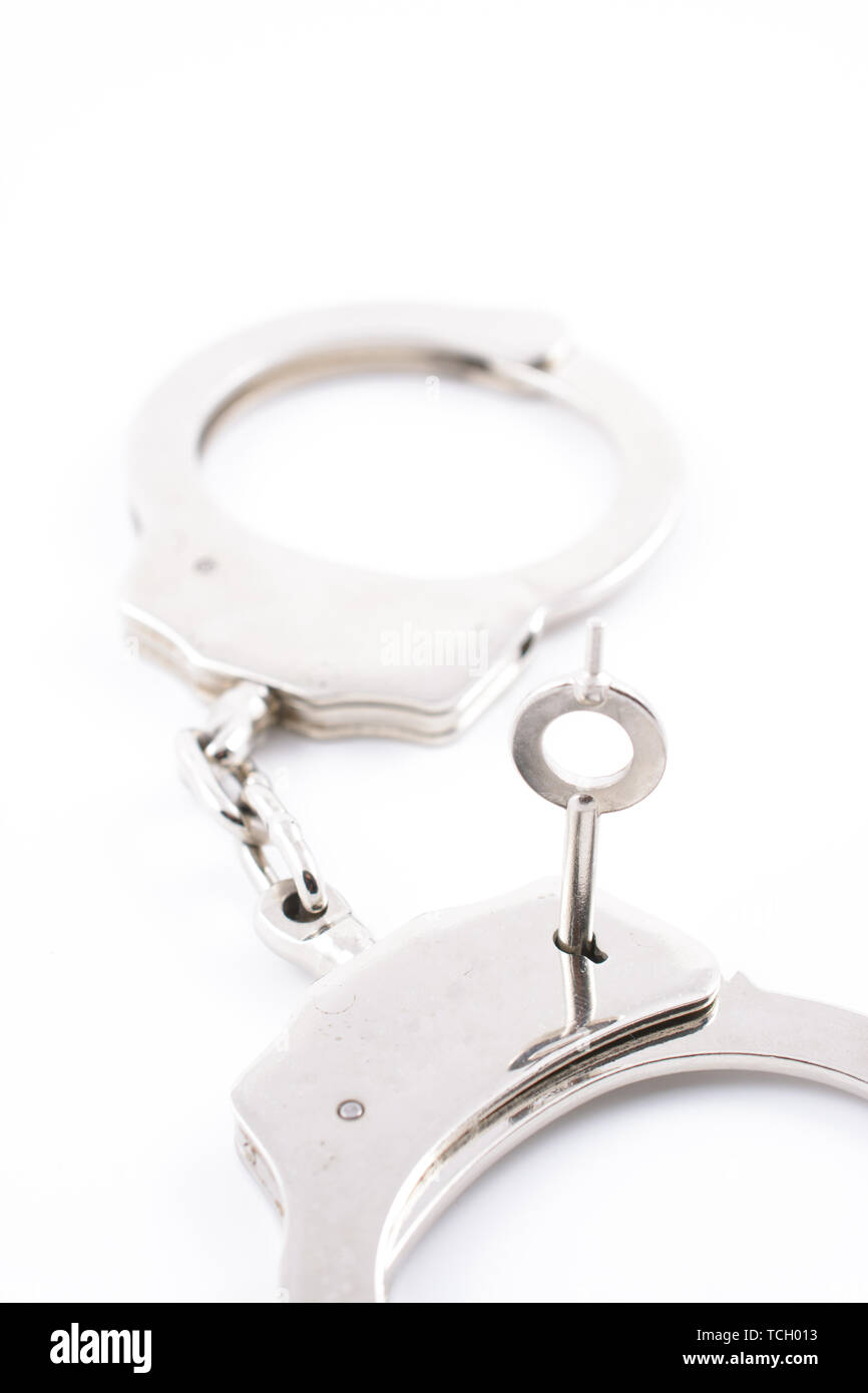Shiny metal chrome handcuffs on a white background Stock Photo - Alamy