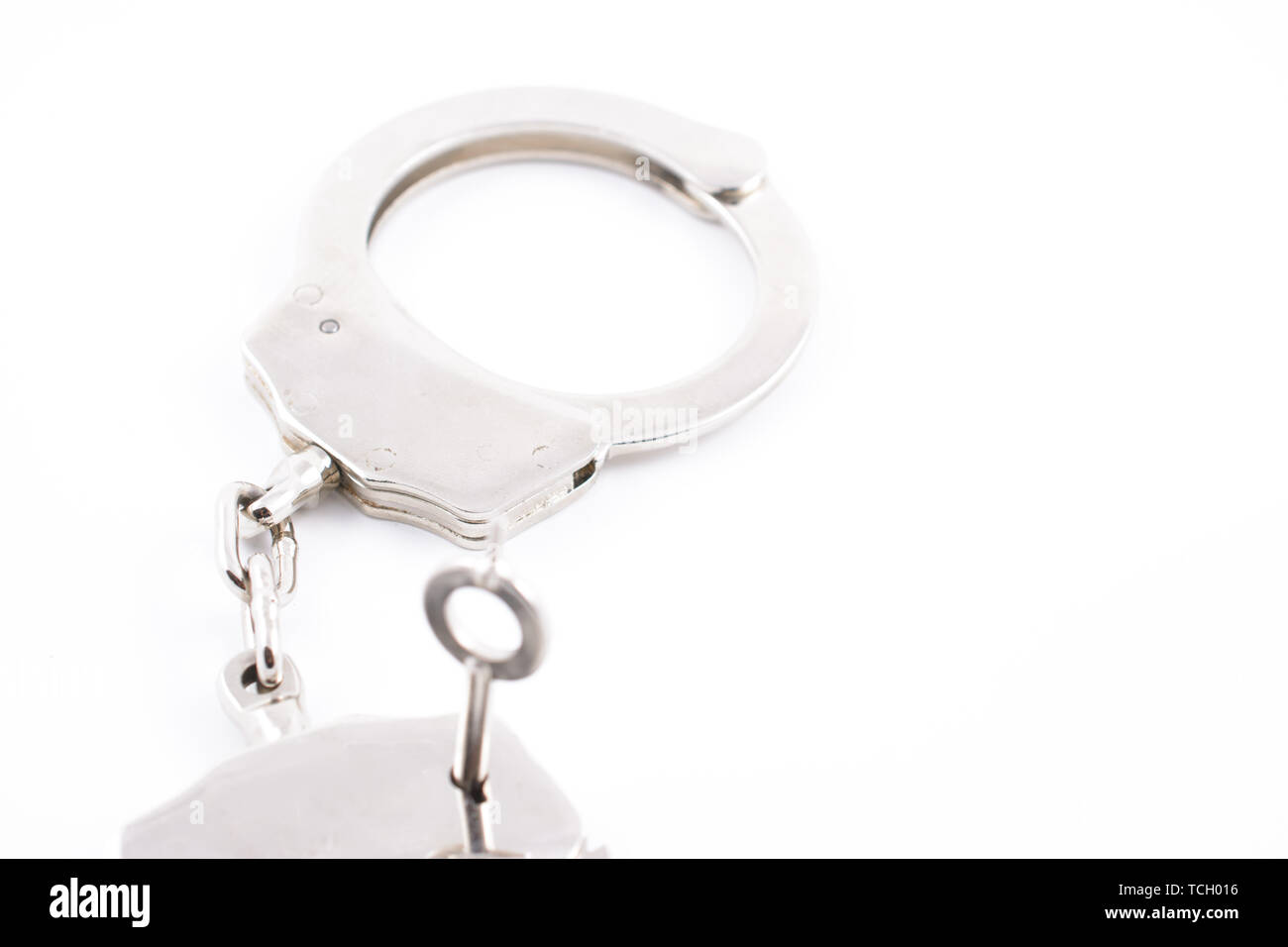 Shiny metal chrome handcuffs on a white background Stock Photo - Alamy