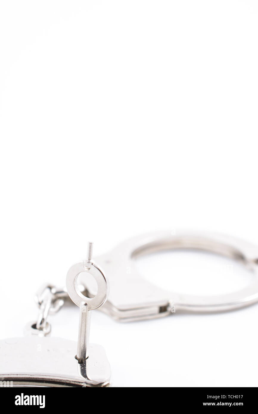 Shiny metal chrome handcuffs on a white background Stock Photo - Alamy