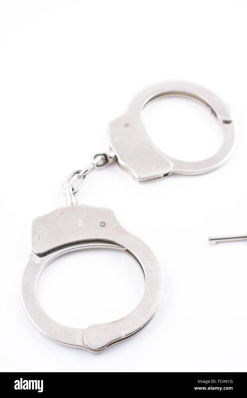 Shiny metal chrome handcuffs on a white background Stock Photo - Alamy
