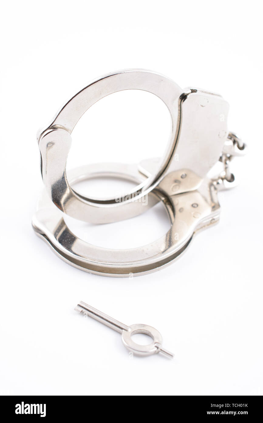 Shiny metal chrome handcuffs on a white background Stock Photo - Alamy