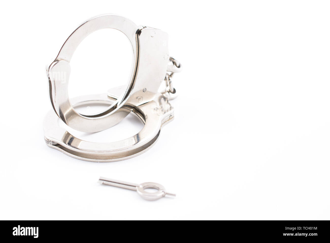 Shiny metal chrome handcuffs on a white background Stock Photo - Alamy