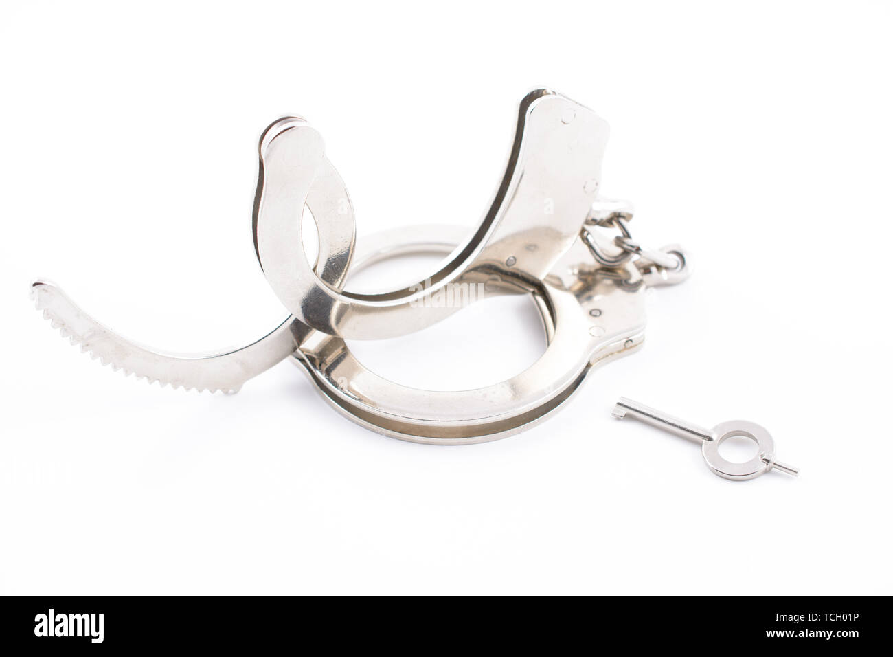 Shiny metal chrome handcuffs on a white background Stock Photo - Alamy