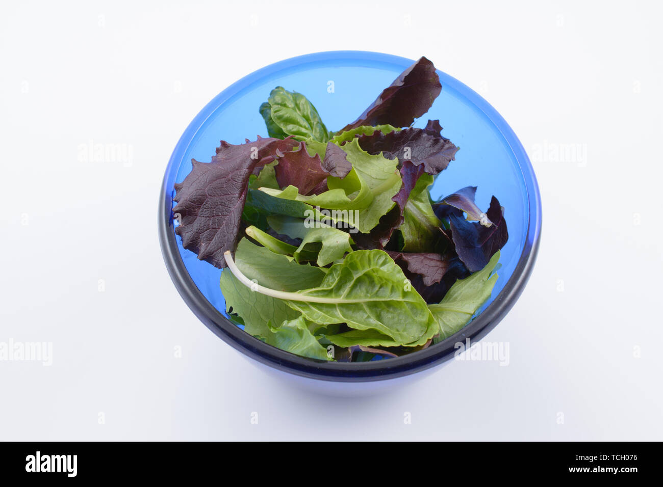 Spring mix salad in a blue bowl on a white isolated background Stock ...