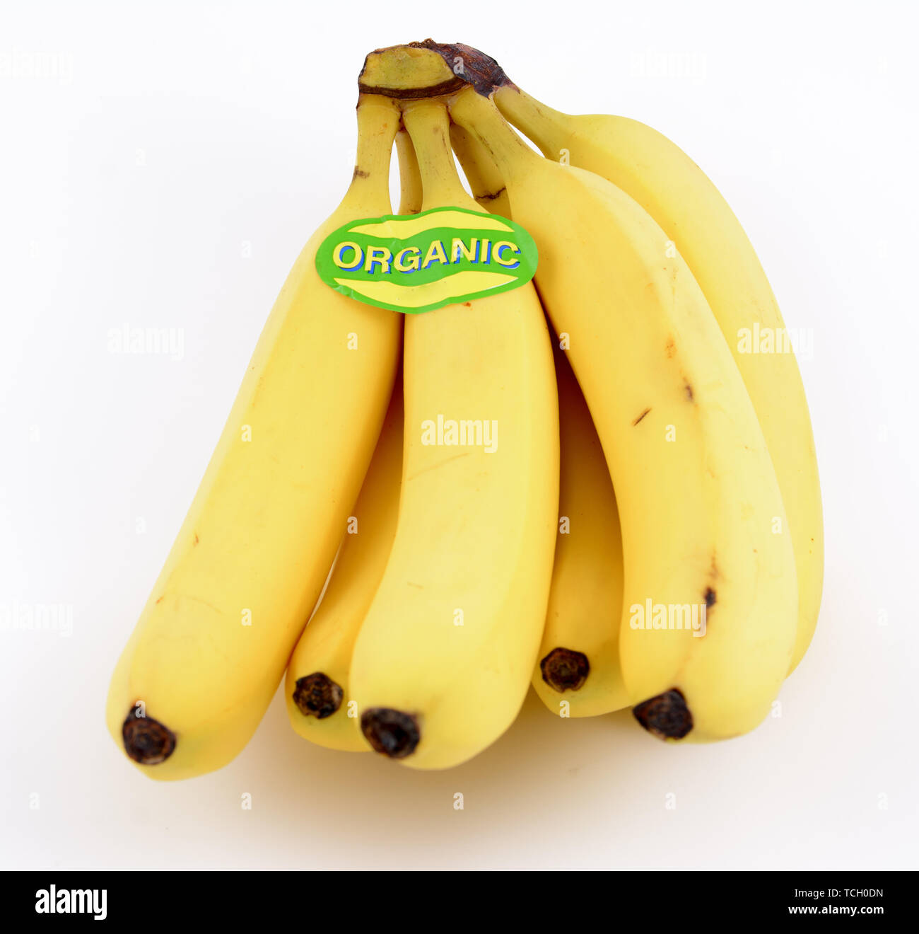 A bunch of yellow organic bananas with a green organic sticker Stock ...