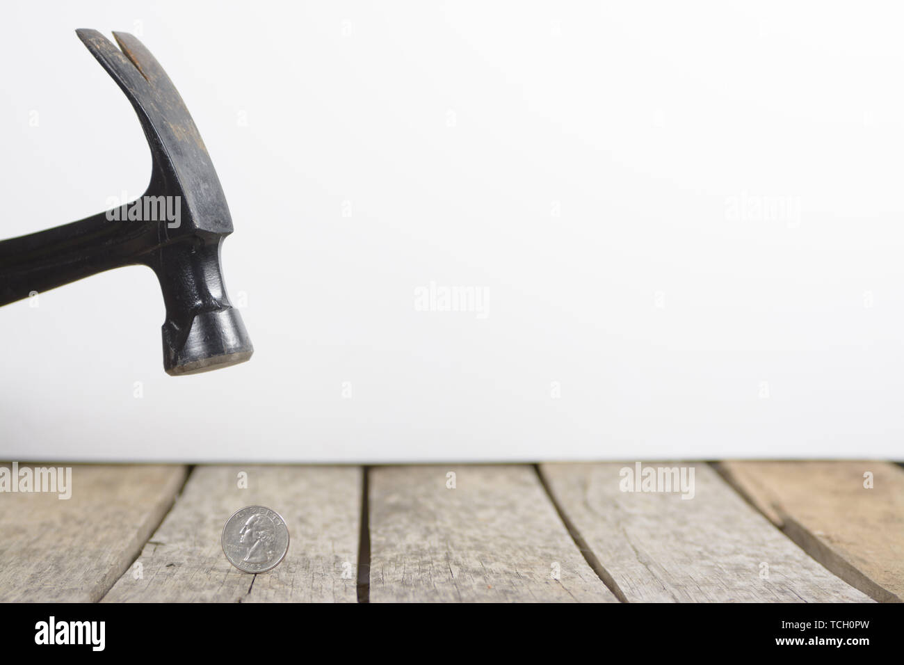 Hammer hammering a quarter coin usa currency Stock Photo - Alamy