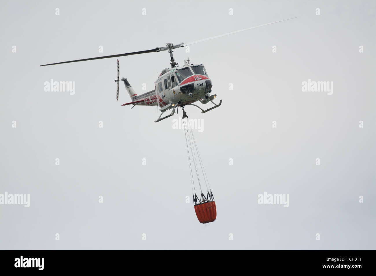 Fire fighting helicopter in flight red bucket hi-res stock photography ...