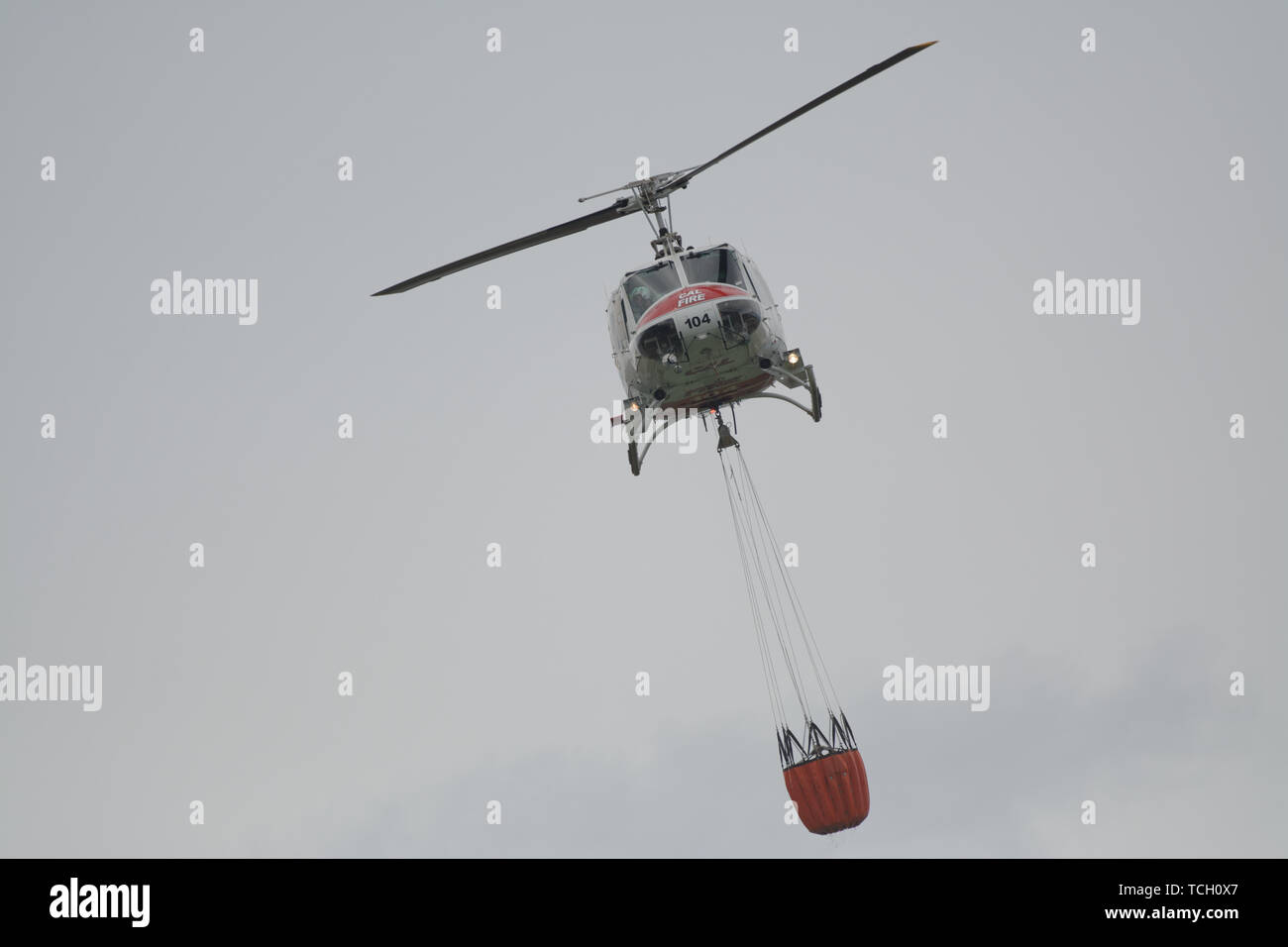 Fire fighting helicopter in flight red bucket hi-res stock photography ...