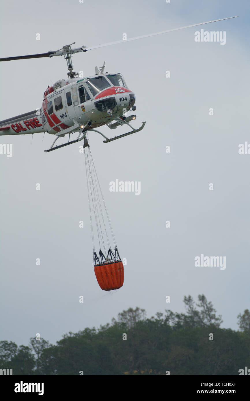 Fire fighting helicopter in flight red bucket hi-res stock photography ...