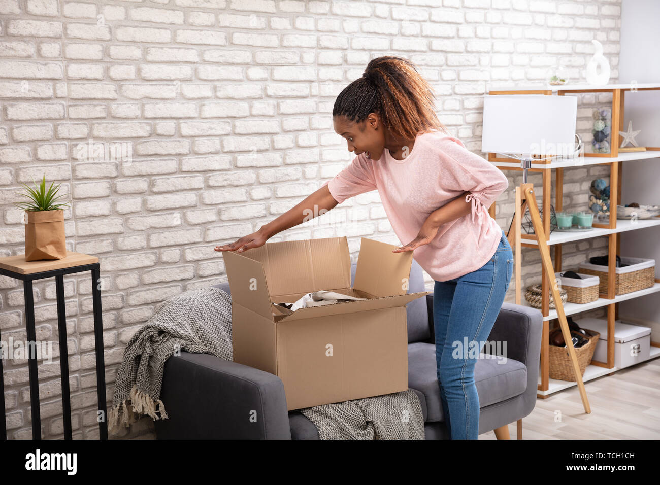 Happy Woman Opening The Parcel Box At Home Stock Photo - Alamy