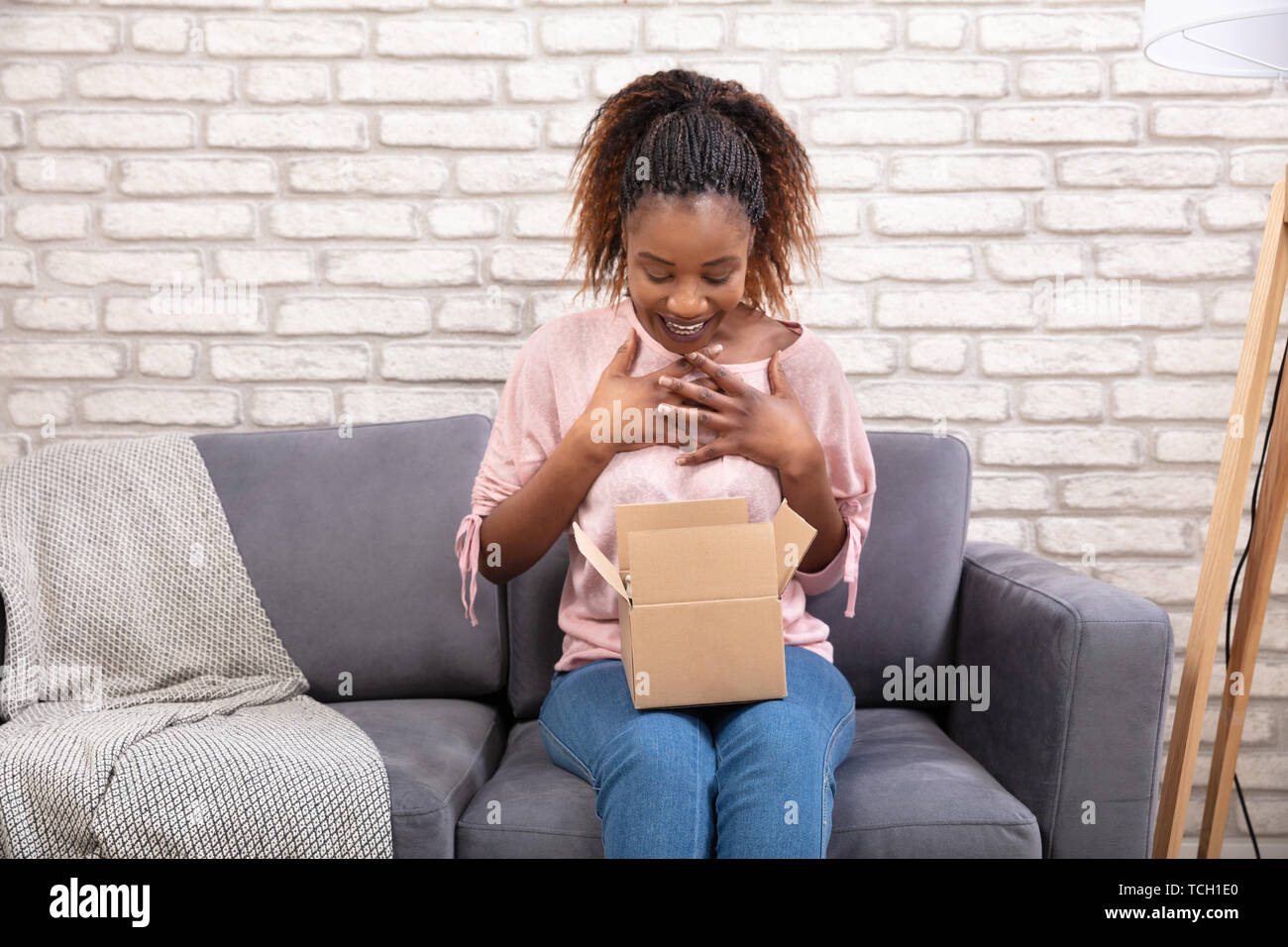 Happy Woman Opening The Parcel Box At Home Stock Photo - Alamy