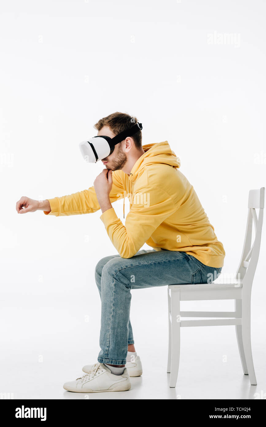 young man in virtual reality headset imitating writing while sitting on ...
