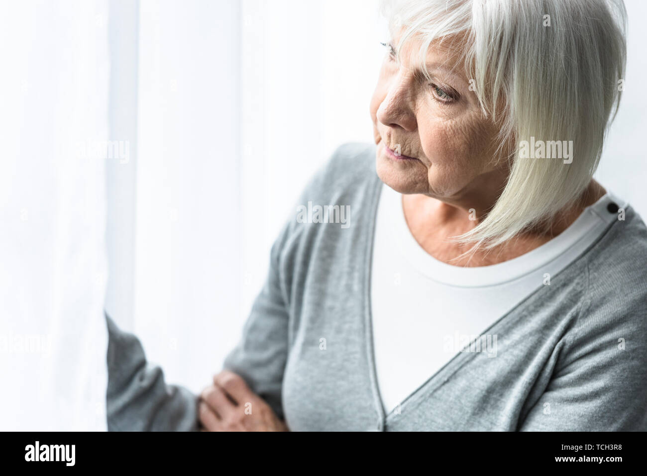pensive senior woman with grey hair looking away at home Stock Photo ...