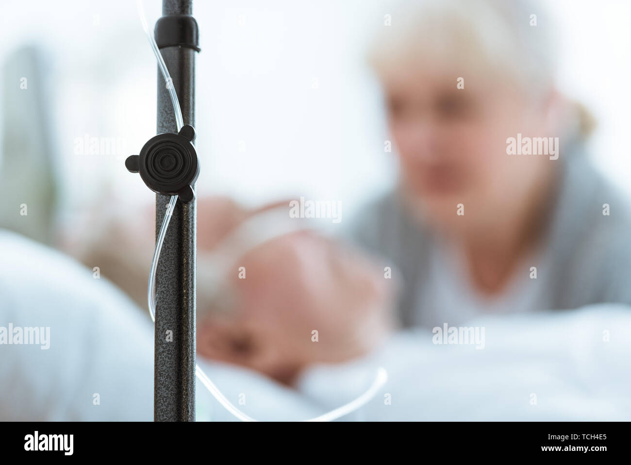selective focus of sad senior woman with husband in coma in clinic ...