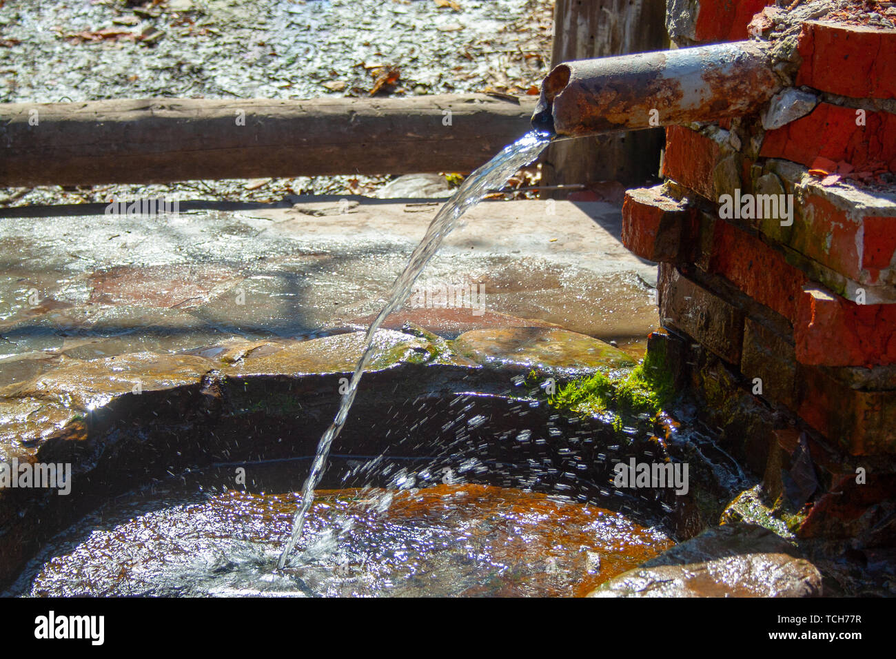 Natural spring folded of old bricks and metallic pipe. Clean fresh ...