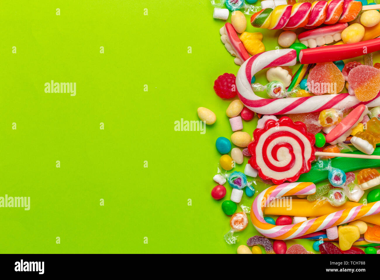 Colorful candies on green background Stock Photo - Alamy