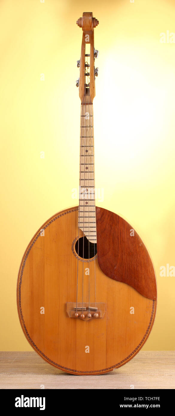 Retro kobza- Ukrainian musical instrument on wooden table on yellow ...