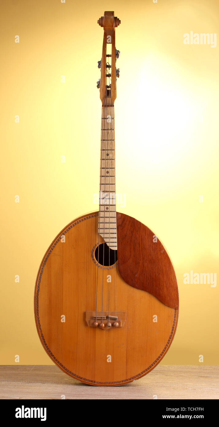 Retro kobza- Ukrainian musical instrument on wooden table on yellow ...