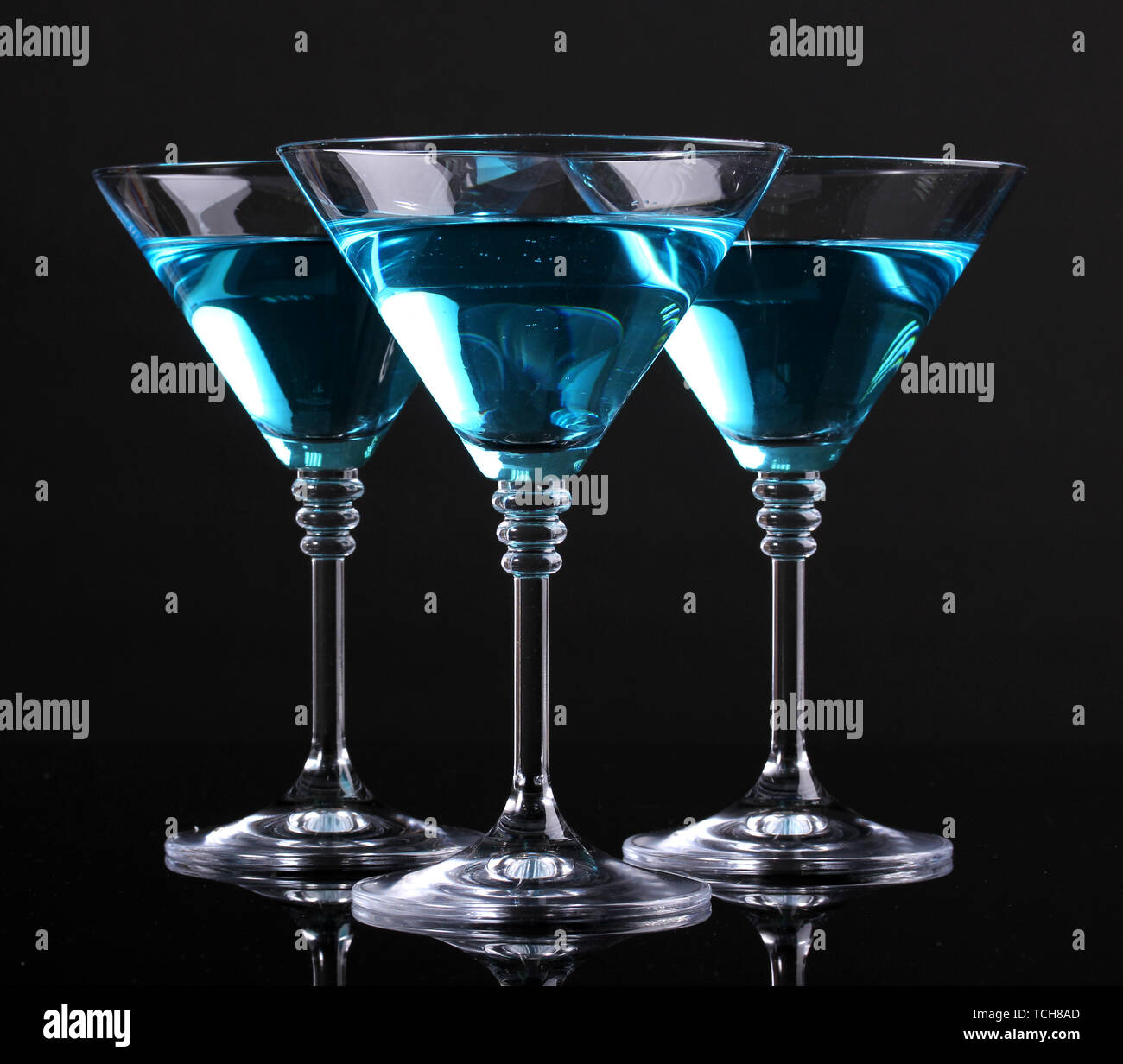 Blue cocktail in martini glasses isolated on black Stock Photo - Alamy