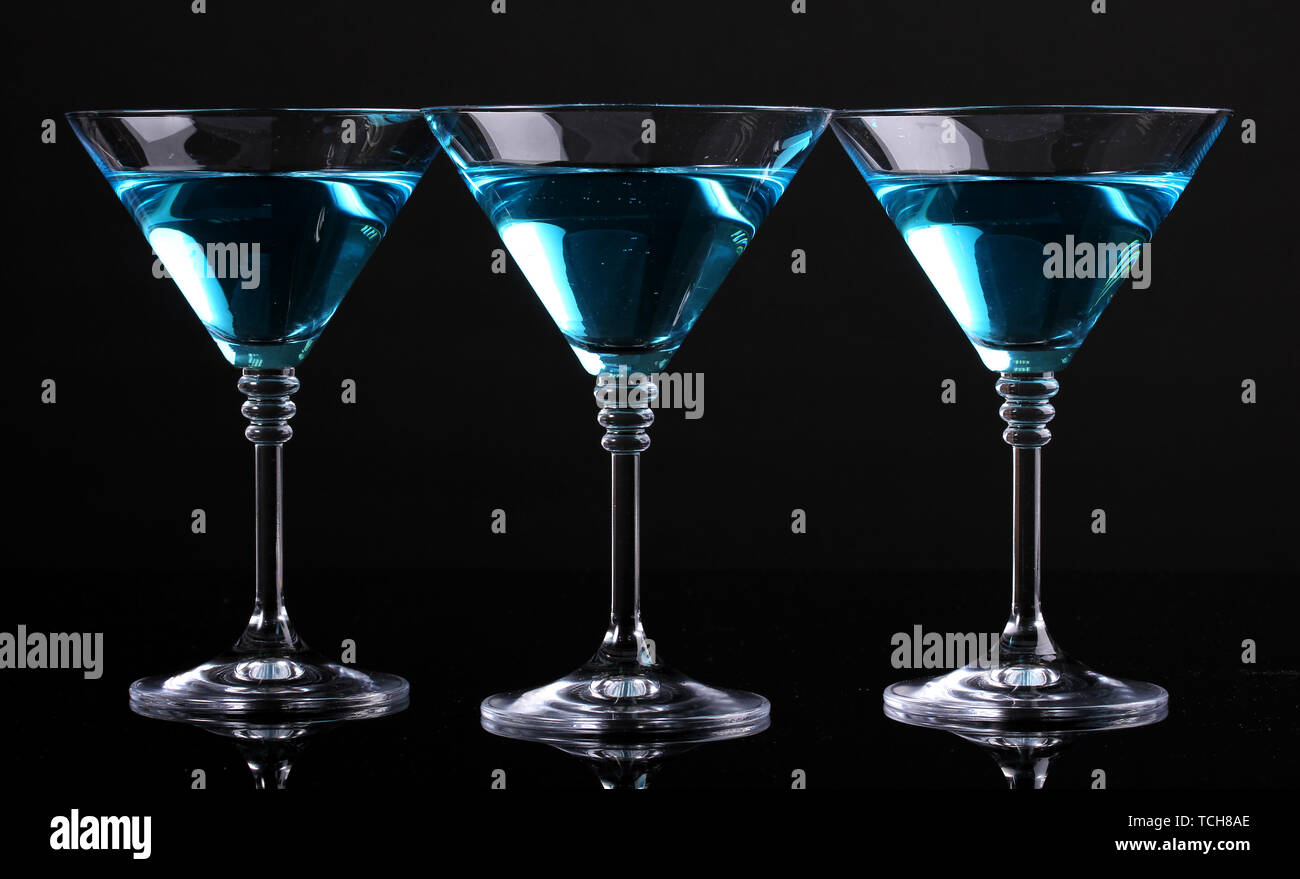 Blue cocktail in martini glasses isolated on black Stock Photo - Alamy