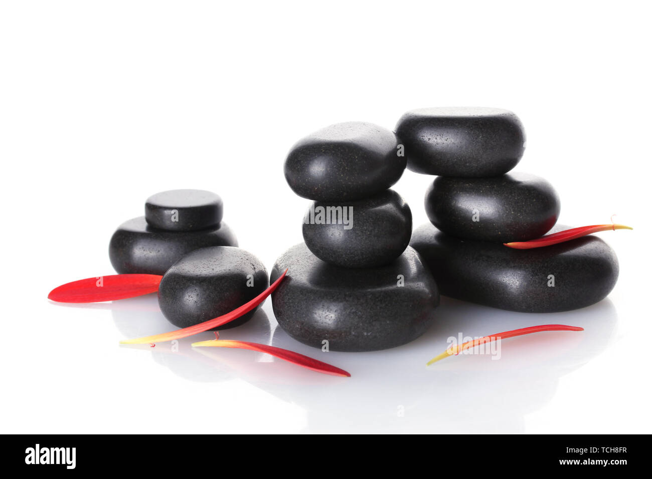 Spa stones and red petals isolated on white Stock Photo - Alamy