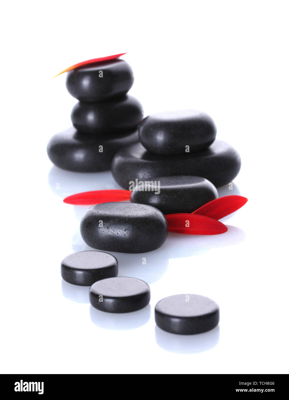 Spa stones and red petals isolated on white Stock Photo - Alamy