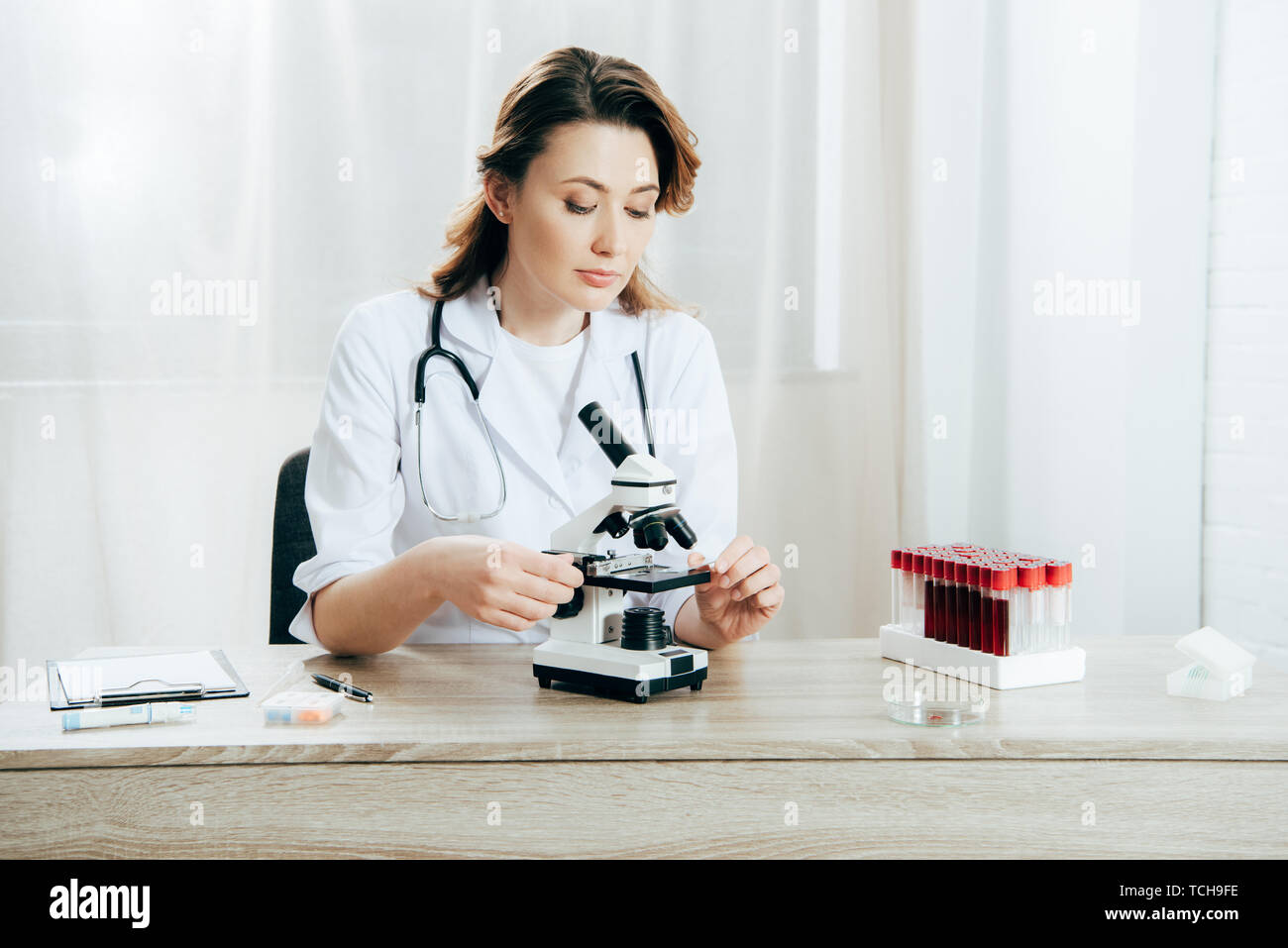 doctor in white coat using microscope in clinic Stock Photo - Alamy