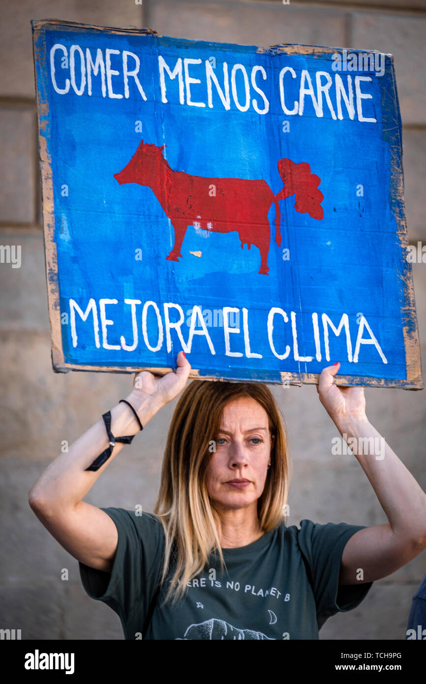 A protester holds a placard that says eating less meat improves the ...