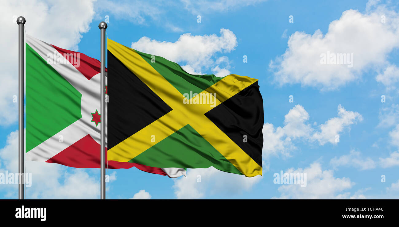 Burundi And Jamaica Flag Waving In The Wind Against White Cloudy Blue