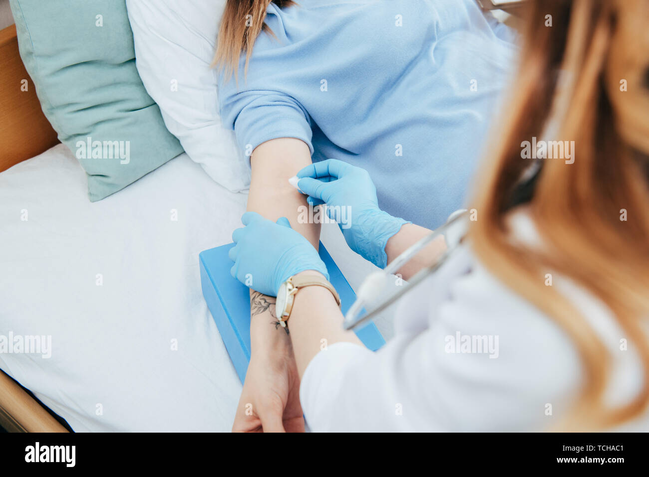 partial view of doctor in latex gloves preparing patient for injection ...