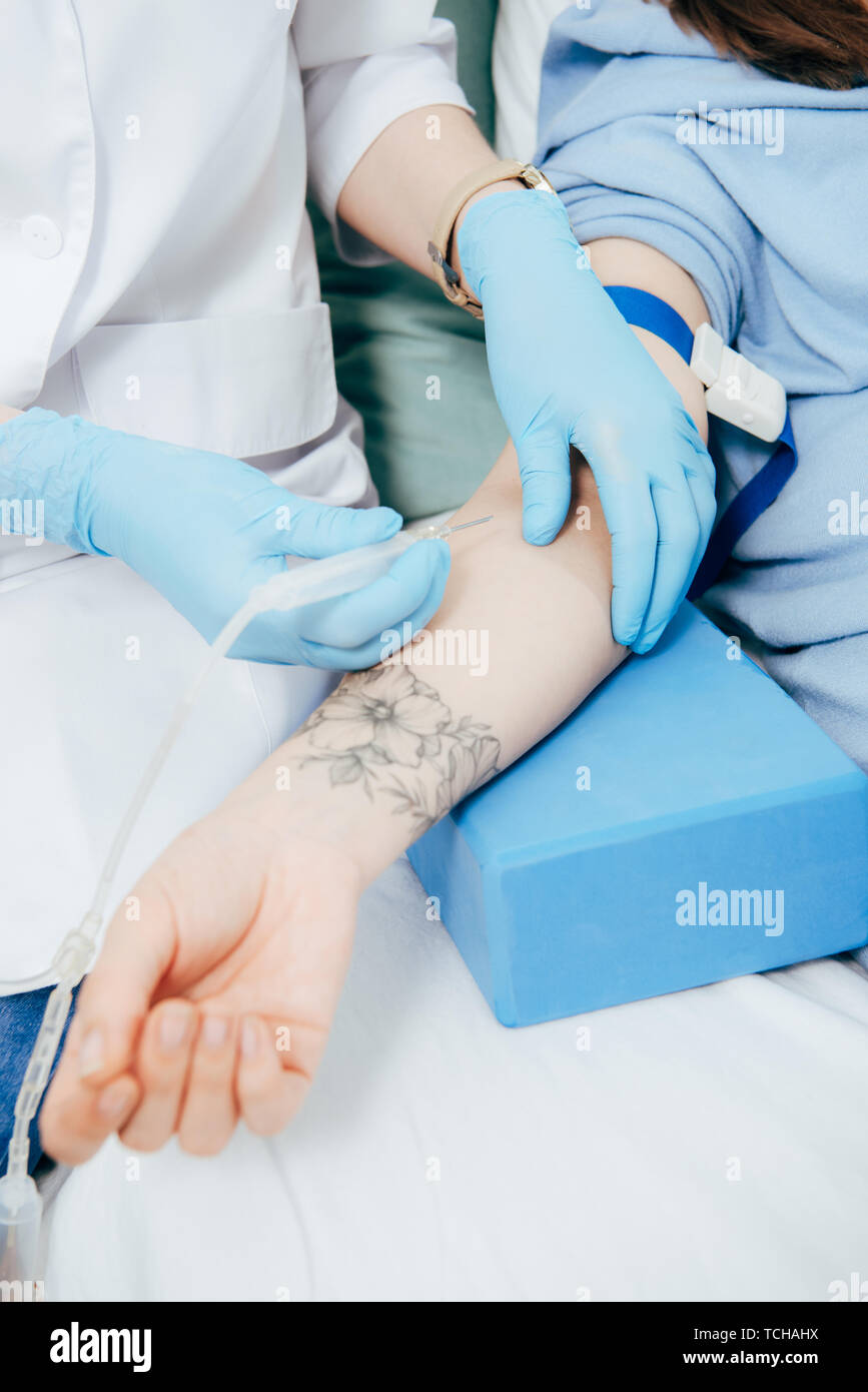 cropped view of doctor in latex gloves doing injection in hospital ...