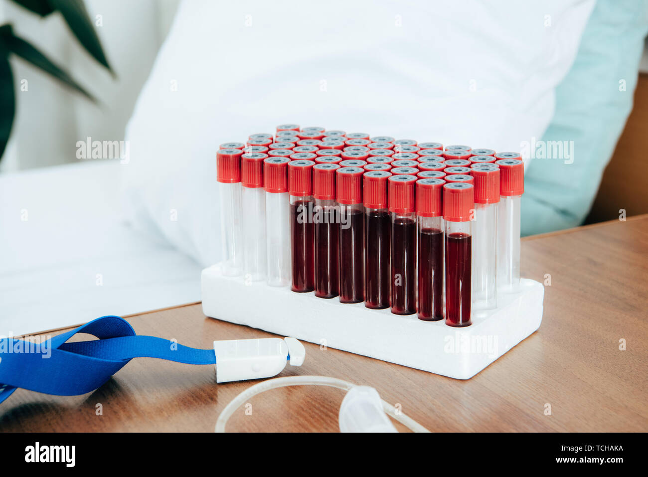 tourniquet and test tubes with blood near bed in clinic Stock Photo - Alamy