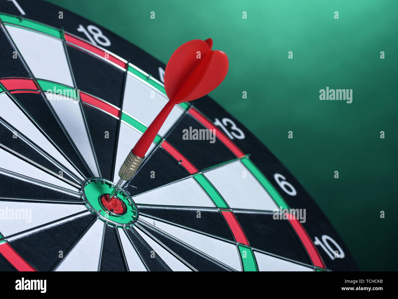 dart board on green background Stock Photo - Alamy