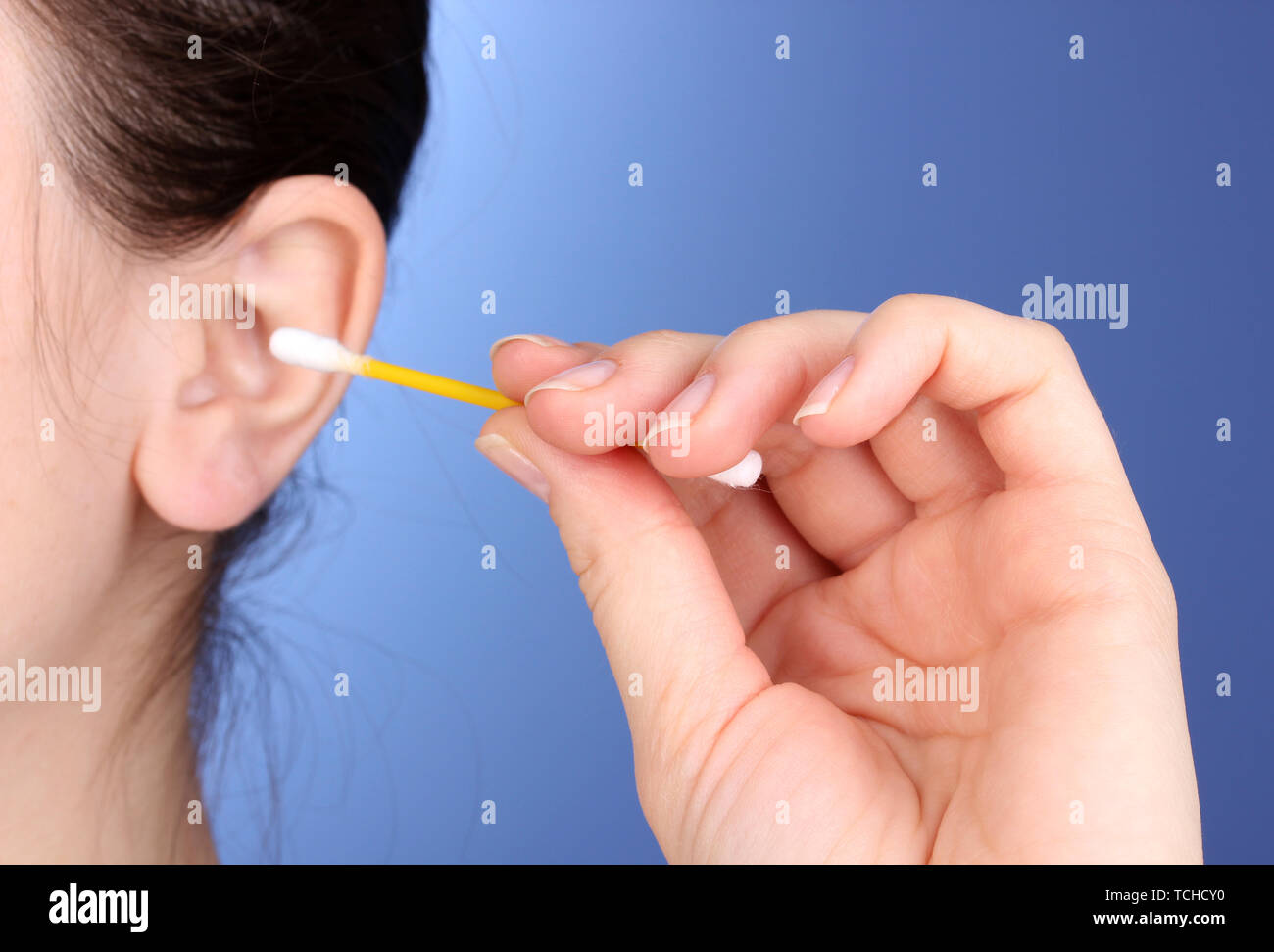 Human ear and cotton swabs close-up on blue background Stock Photo - Alamy