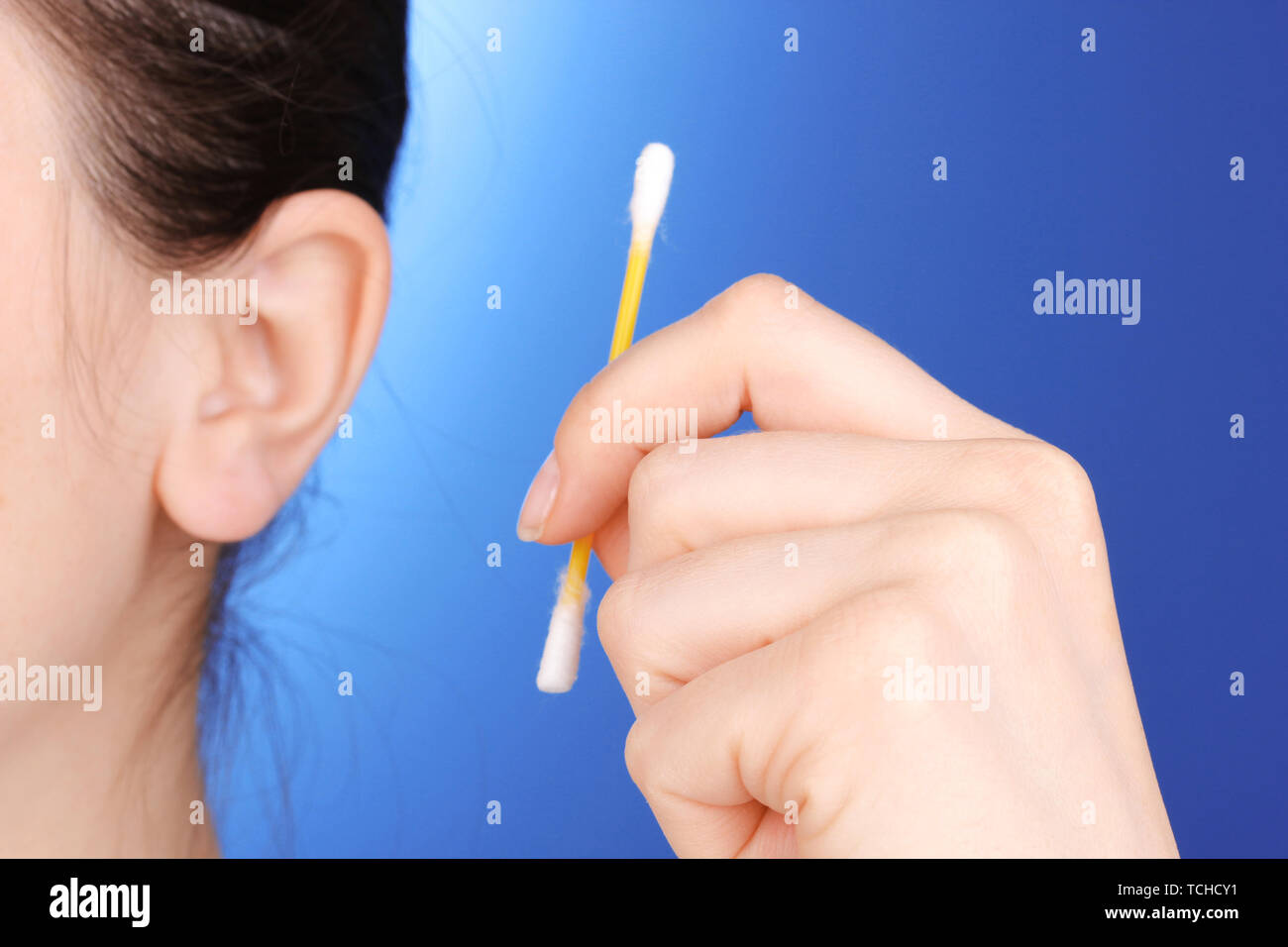 Human ear and cotton swabs close-up on blue background Stock Photo - Alamy