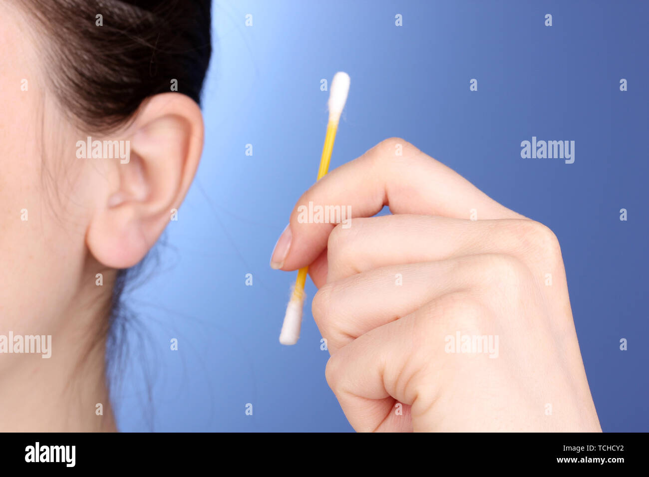 Human ear and cotton swabs close-up on blue background Stock Photo - Alamy