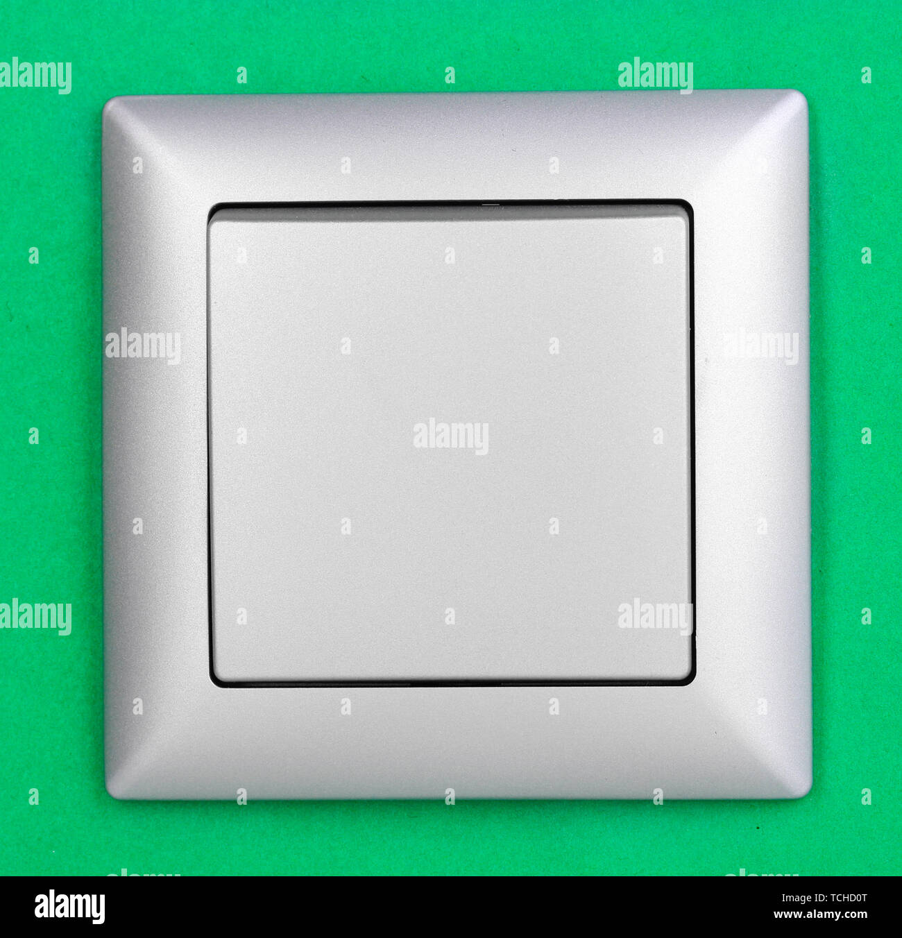 Modern light switch on green background Stock Photo - Alamy