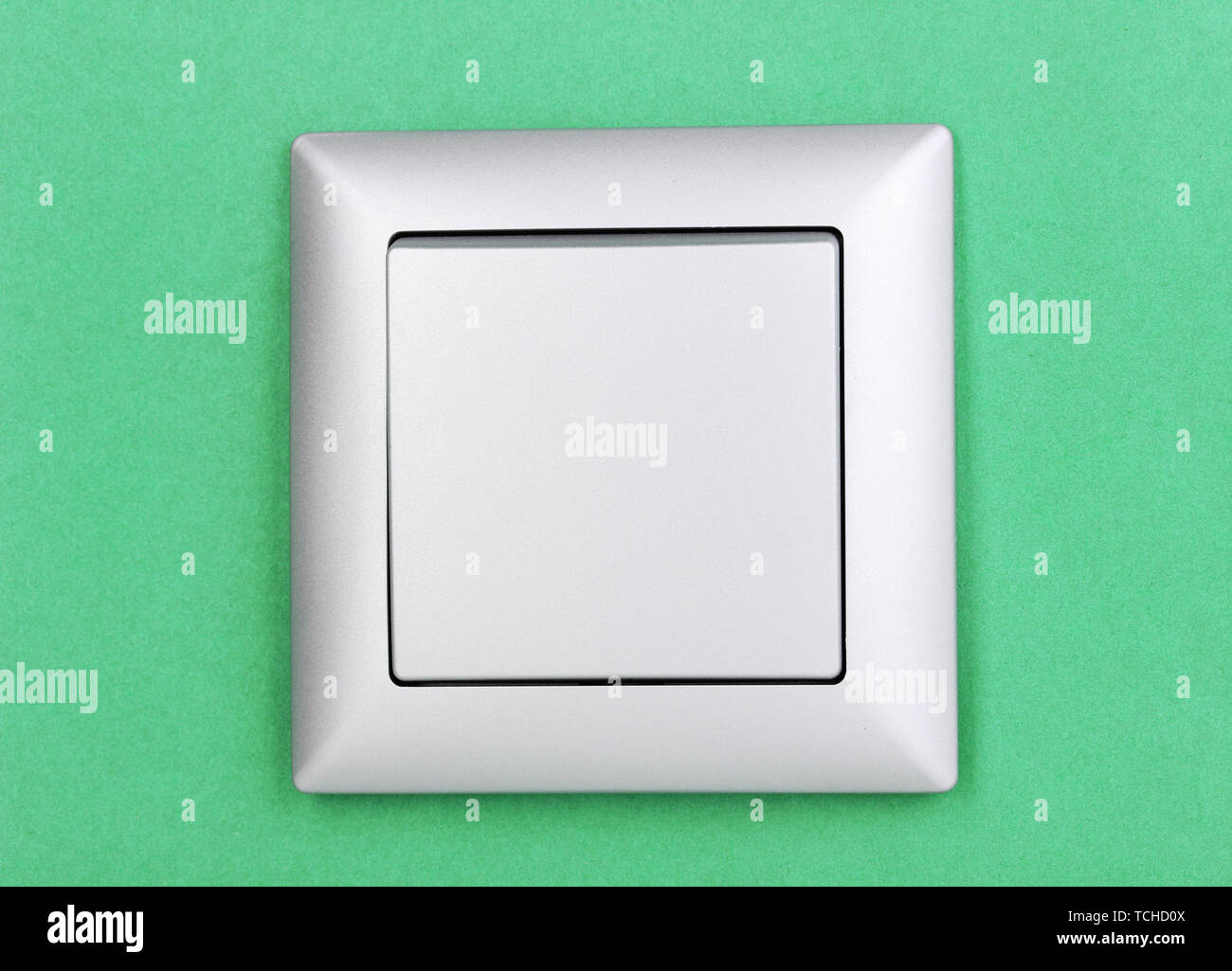 Modern light switch on green background Stock Photo - Alamy