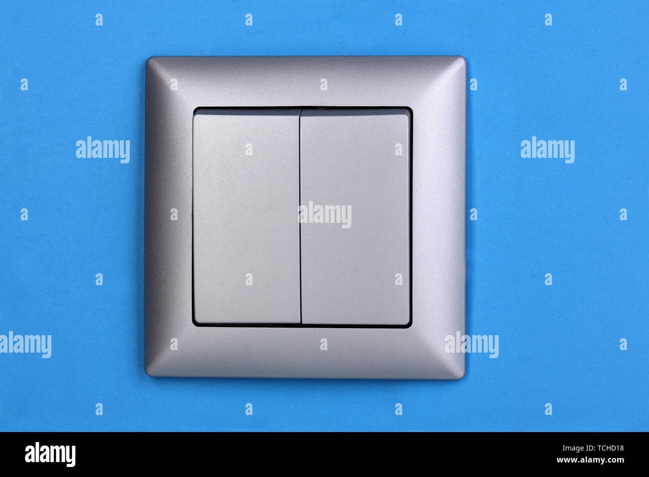 Modern light switch on blue background Stock Photo - Alamy