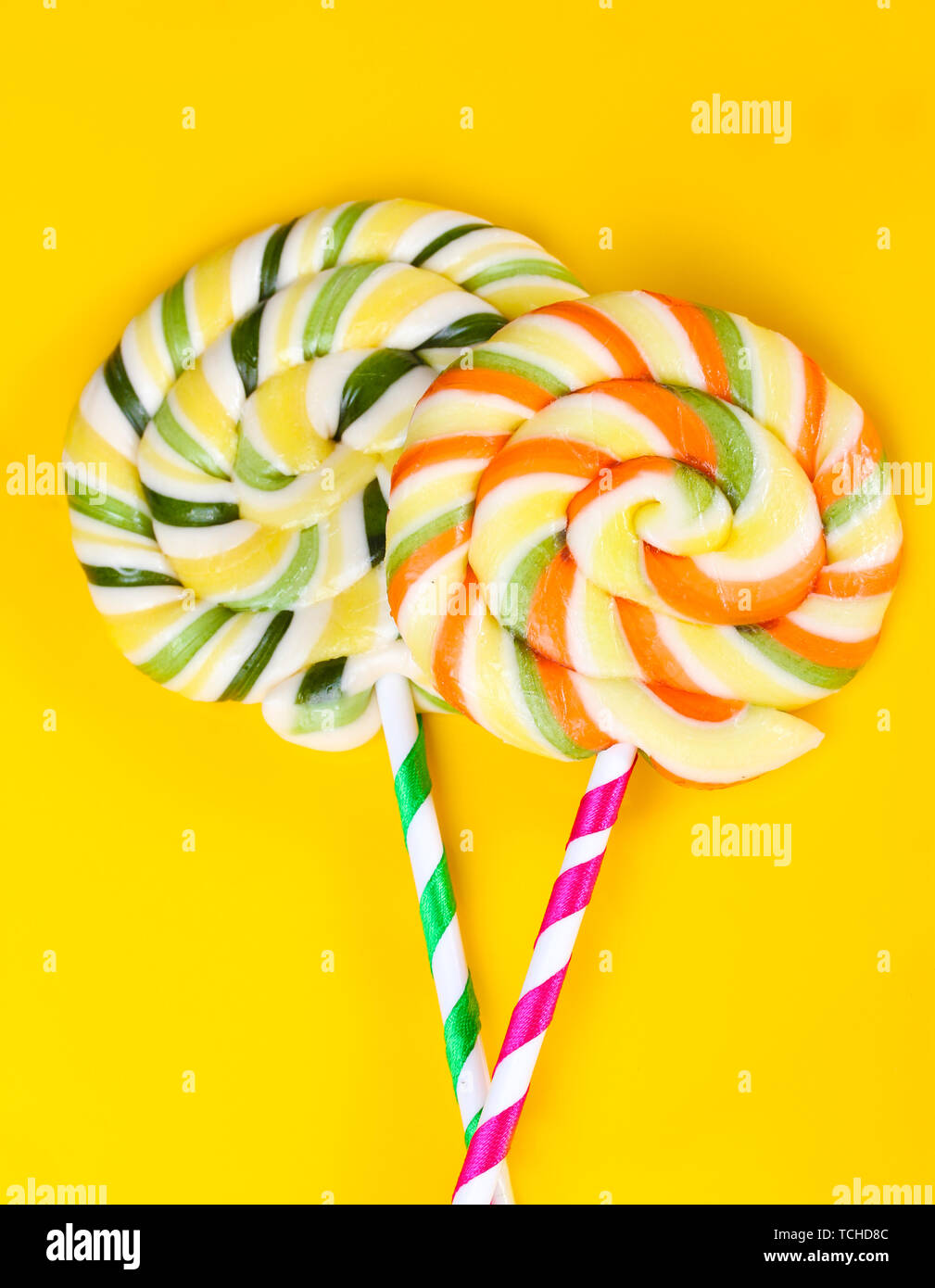 Colorful lollipops on yellow background Stock Photo - Alamy