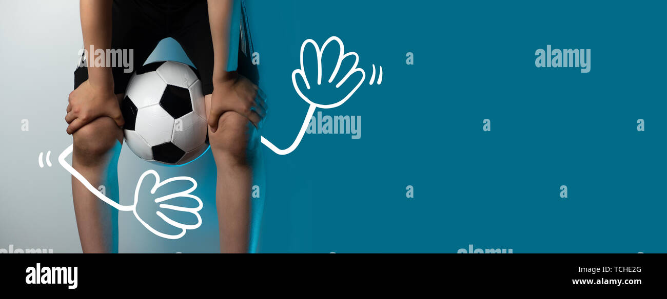 football goalkeeper with dirty knees clamped the ball between his legs ...