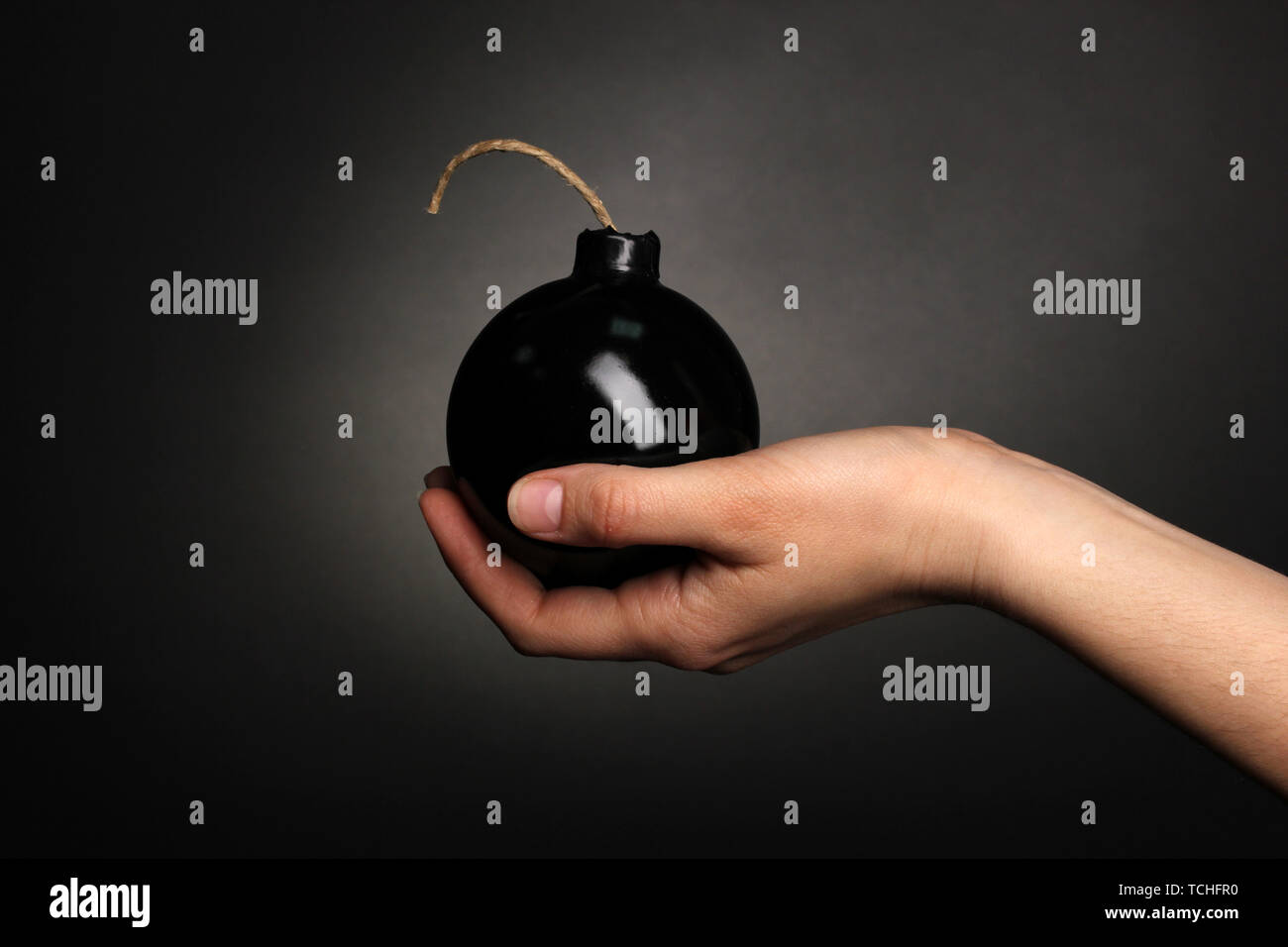 Cartoon style bomb in hand on black background Stock Photo - Alamy