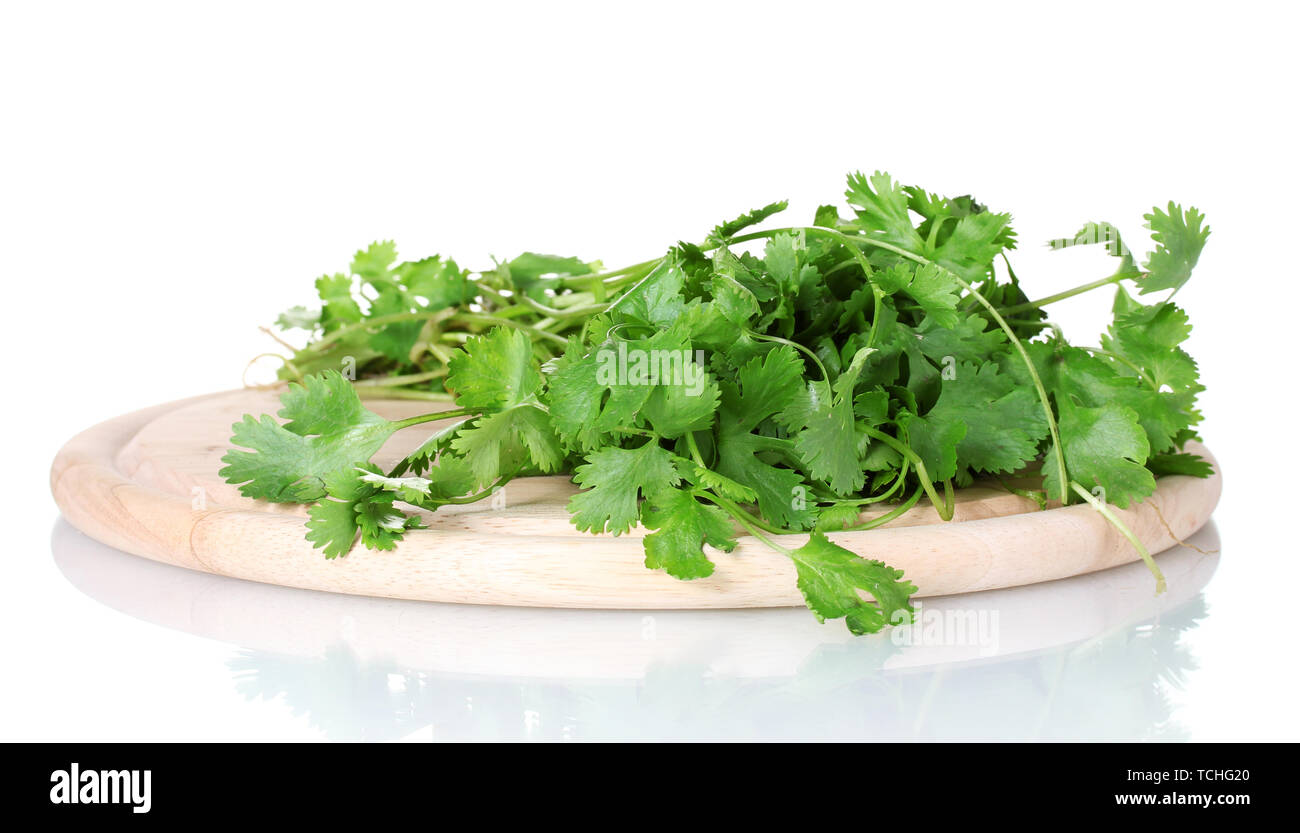 Coriander on a cutting board isolated on white Stock Photo - Alamy