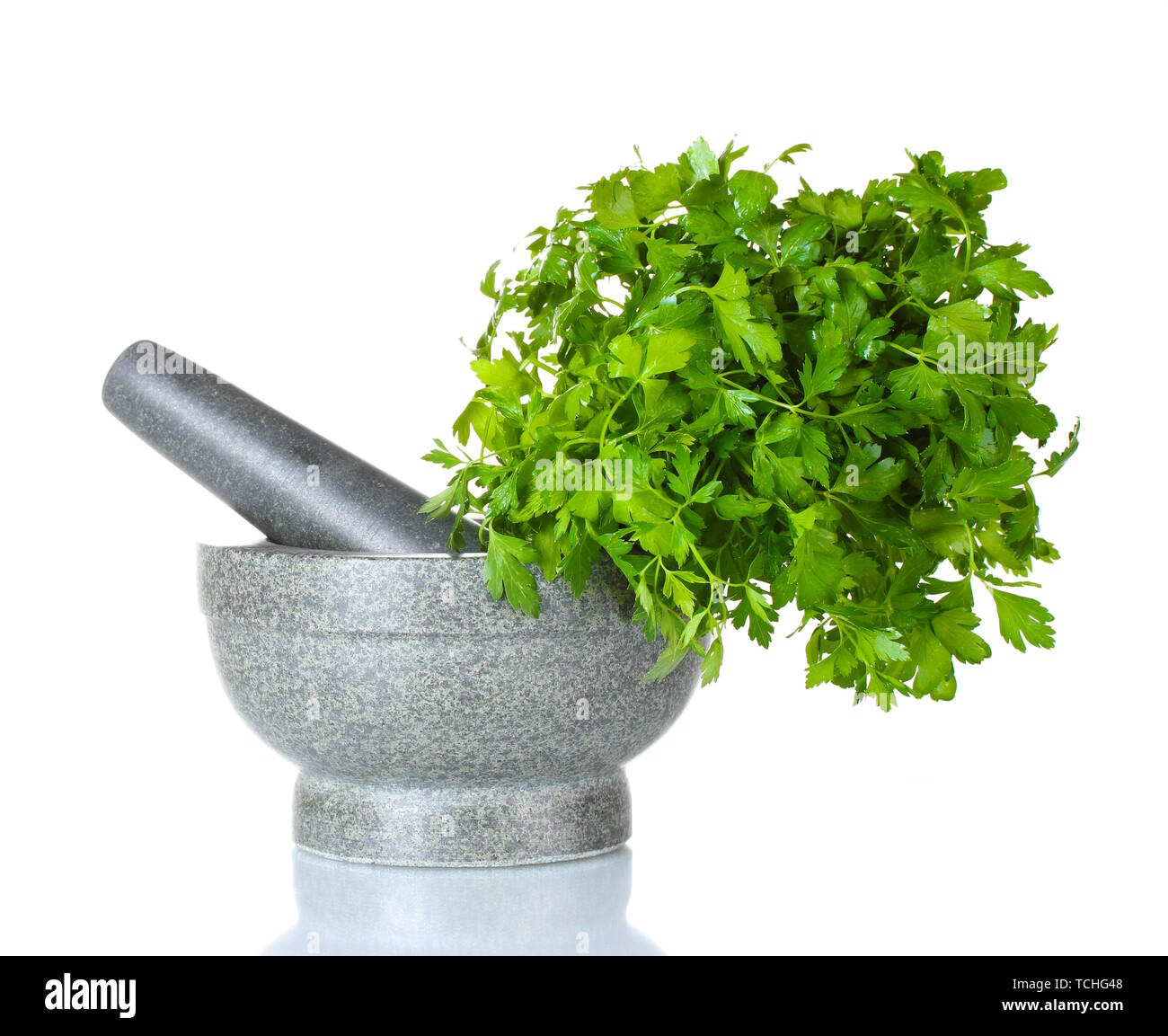 Parsley in a mortar and pestle isolated on white Stock Photo - Alamy