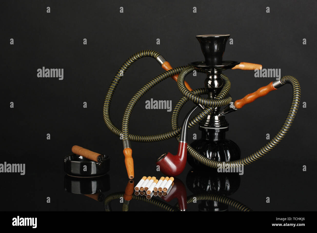 Smoking tools - a hookah, cigar, cigarette and pipe isolated on black ...