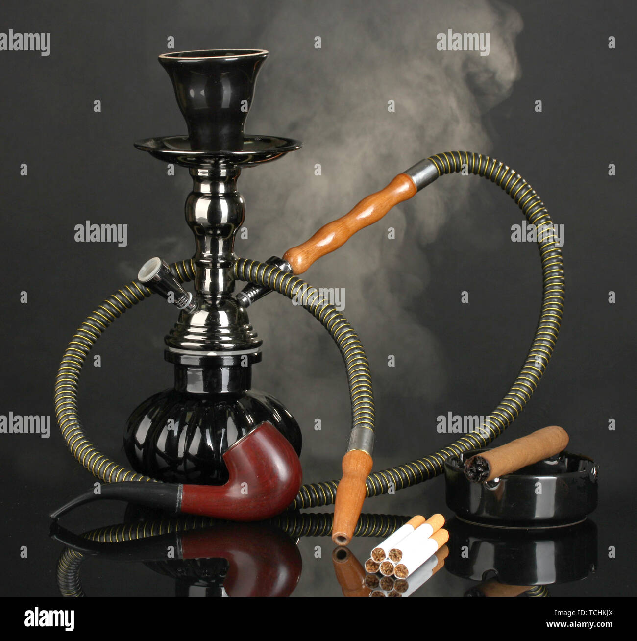 Smoking tools - a hookah, cigar, cigarette and pipe on black background ...