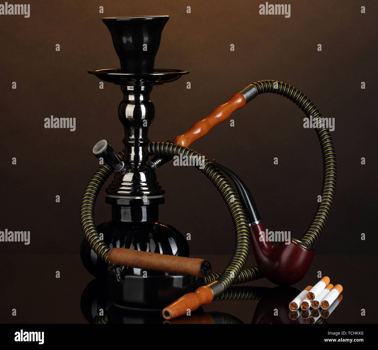 Smoking tools - a hookah, cigar, cigarette and pipe on brown background ...